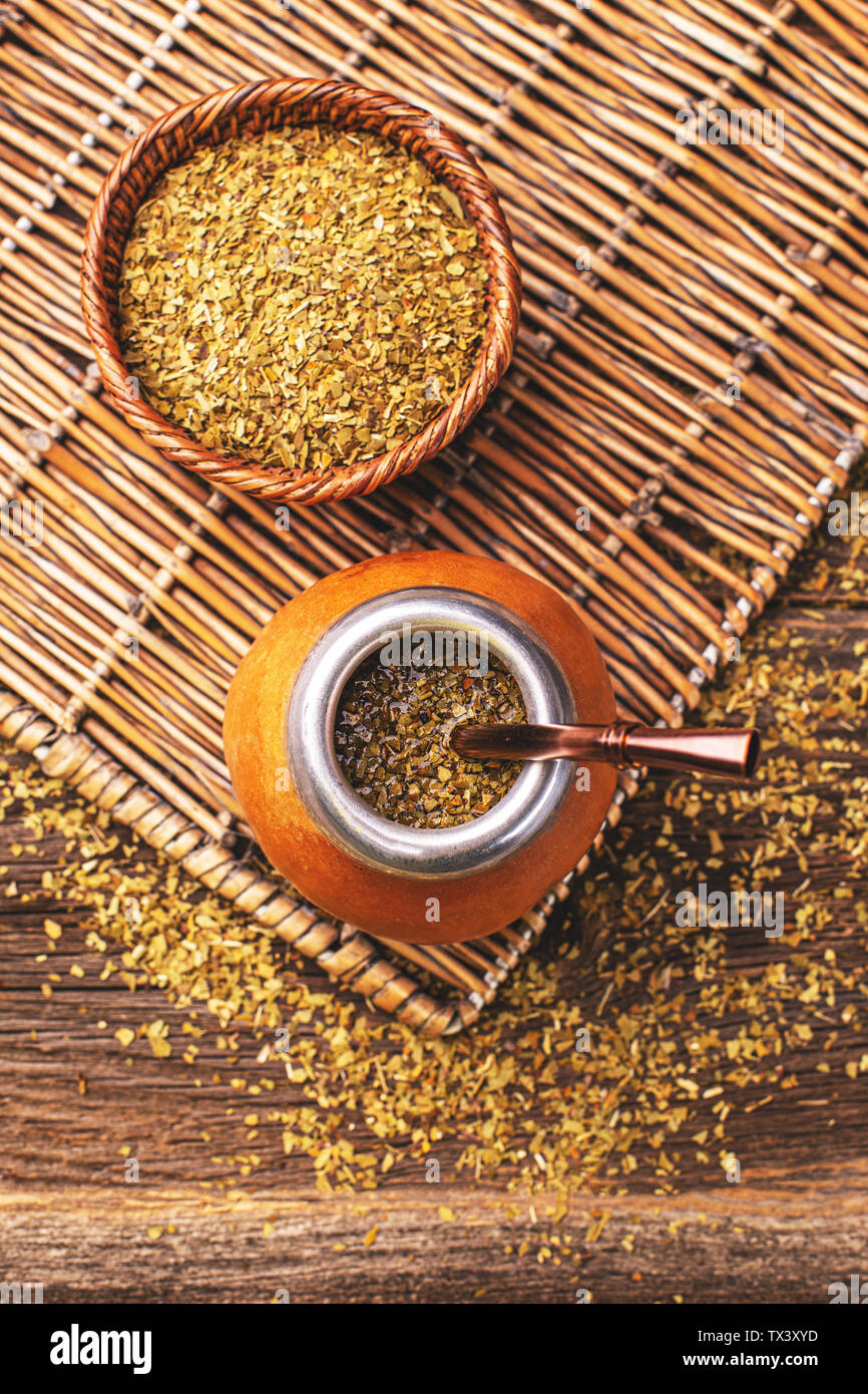 Yerba Mate tea in wooden mate cup with bombilla metal straw serving as ...