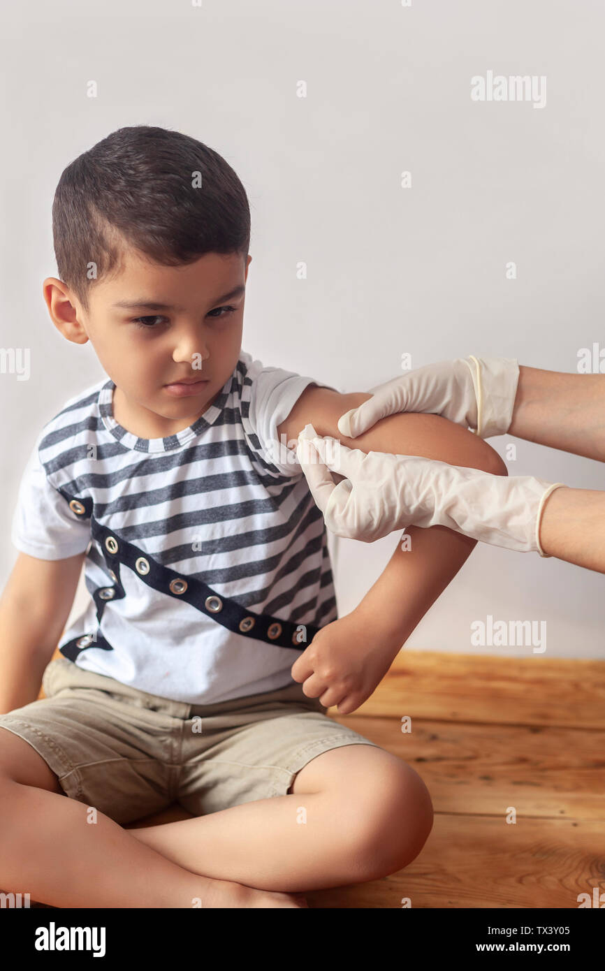 A doctor vaccinating young patient. Little boy scared of injection ...