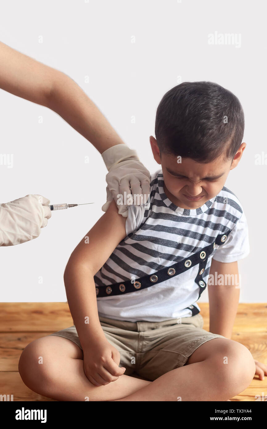 A doctor vaccinating young patient. Little boy scared of injection ...