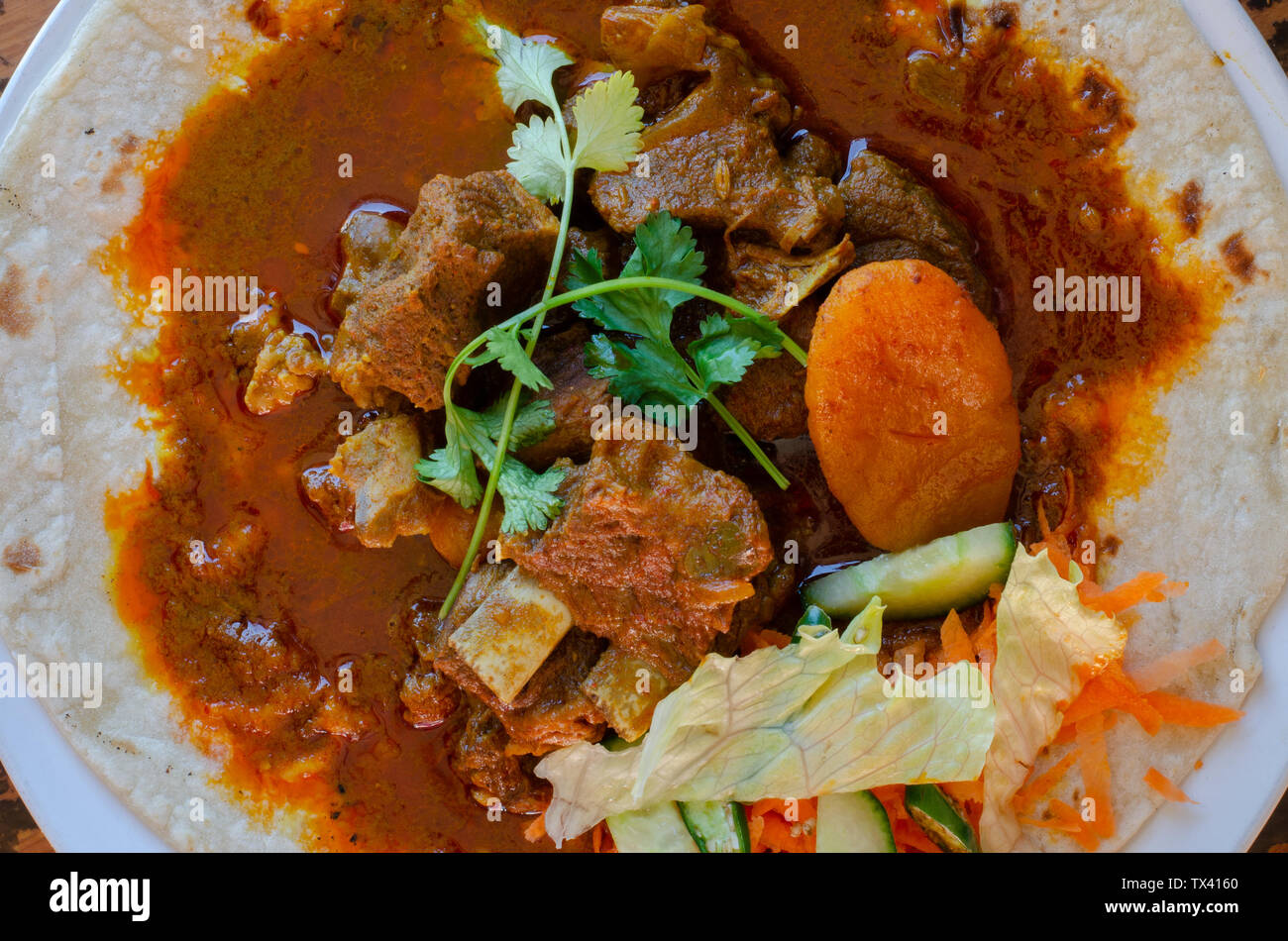 A mutton curry roti with sambals - an iconic Durban meal consisting of ...
