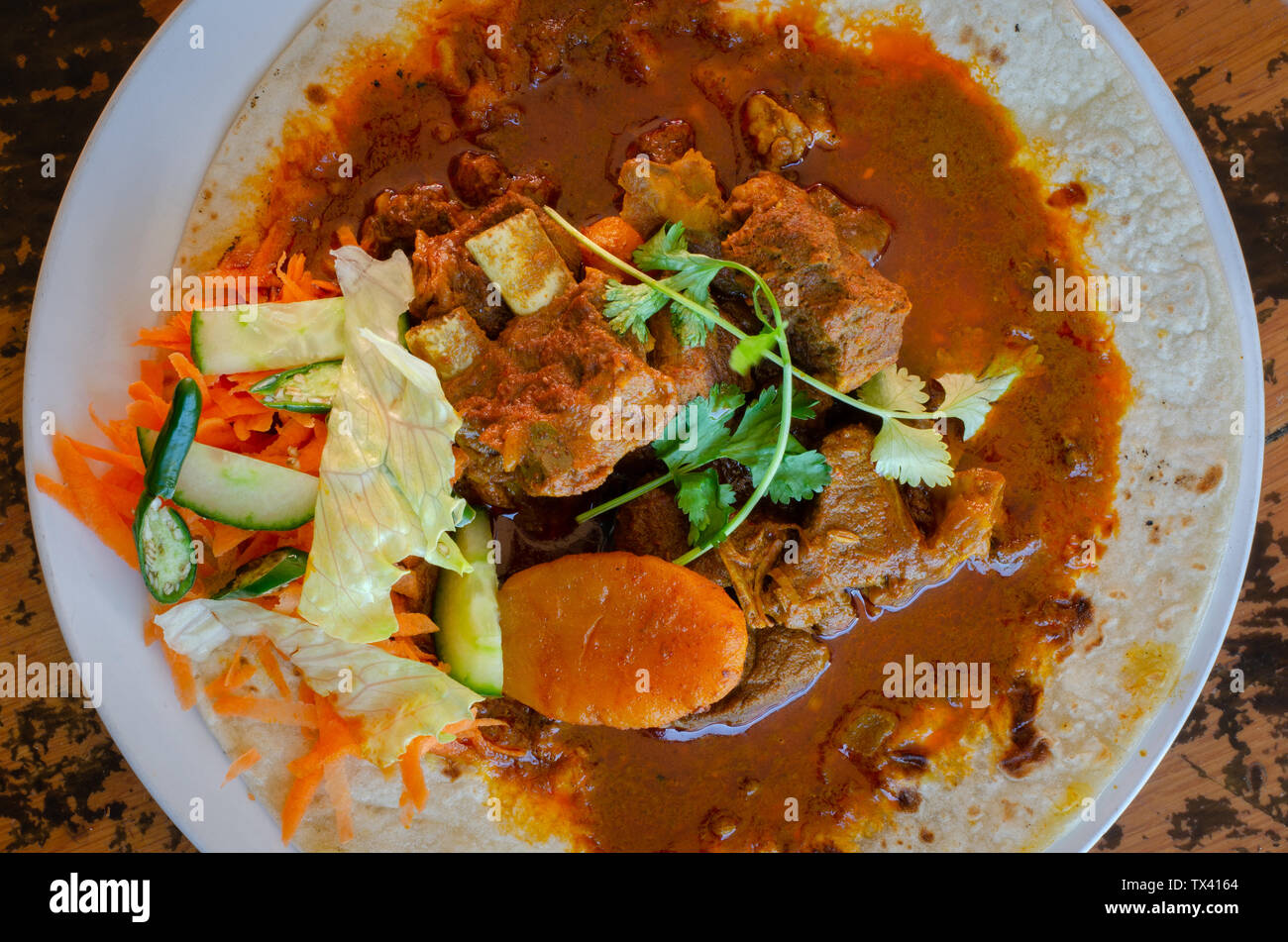 A mutton curry roti with sambals - an iconic Durban meal consisting of ...