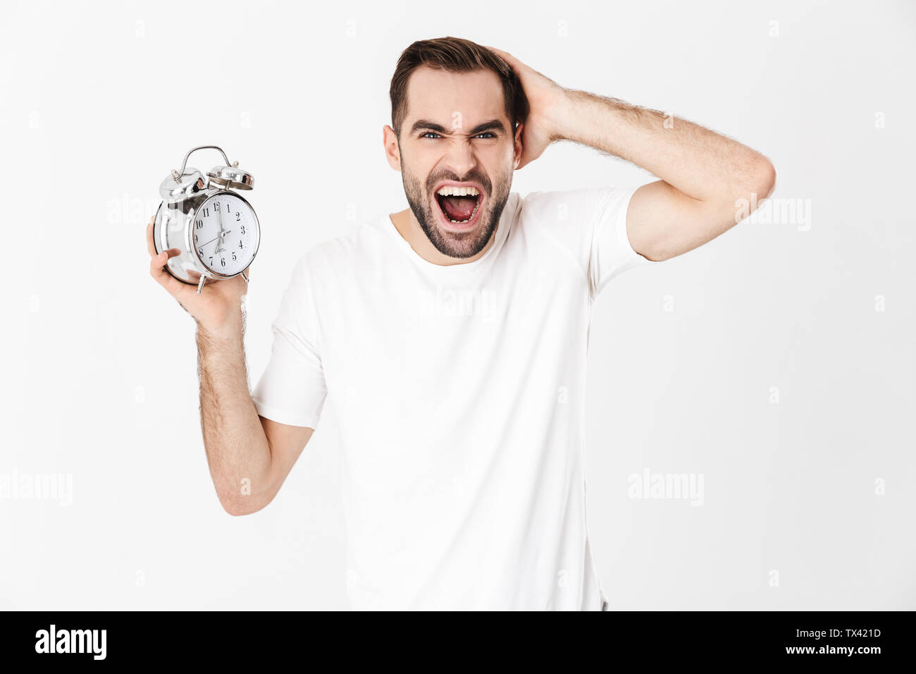 Handsome angry man wearing blank t-shirt standing isolated over white ...