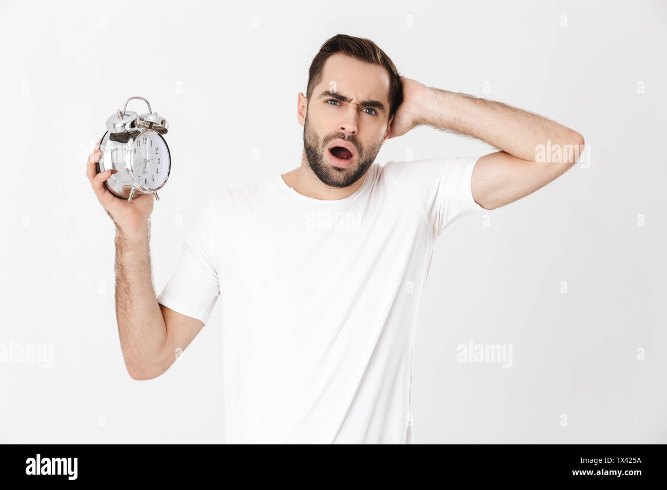 Handsome angry man wearing blank t-shirt standing isolated over white ...