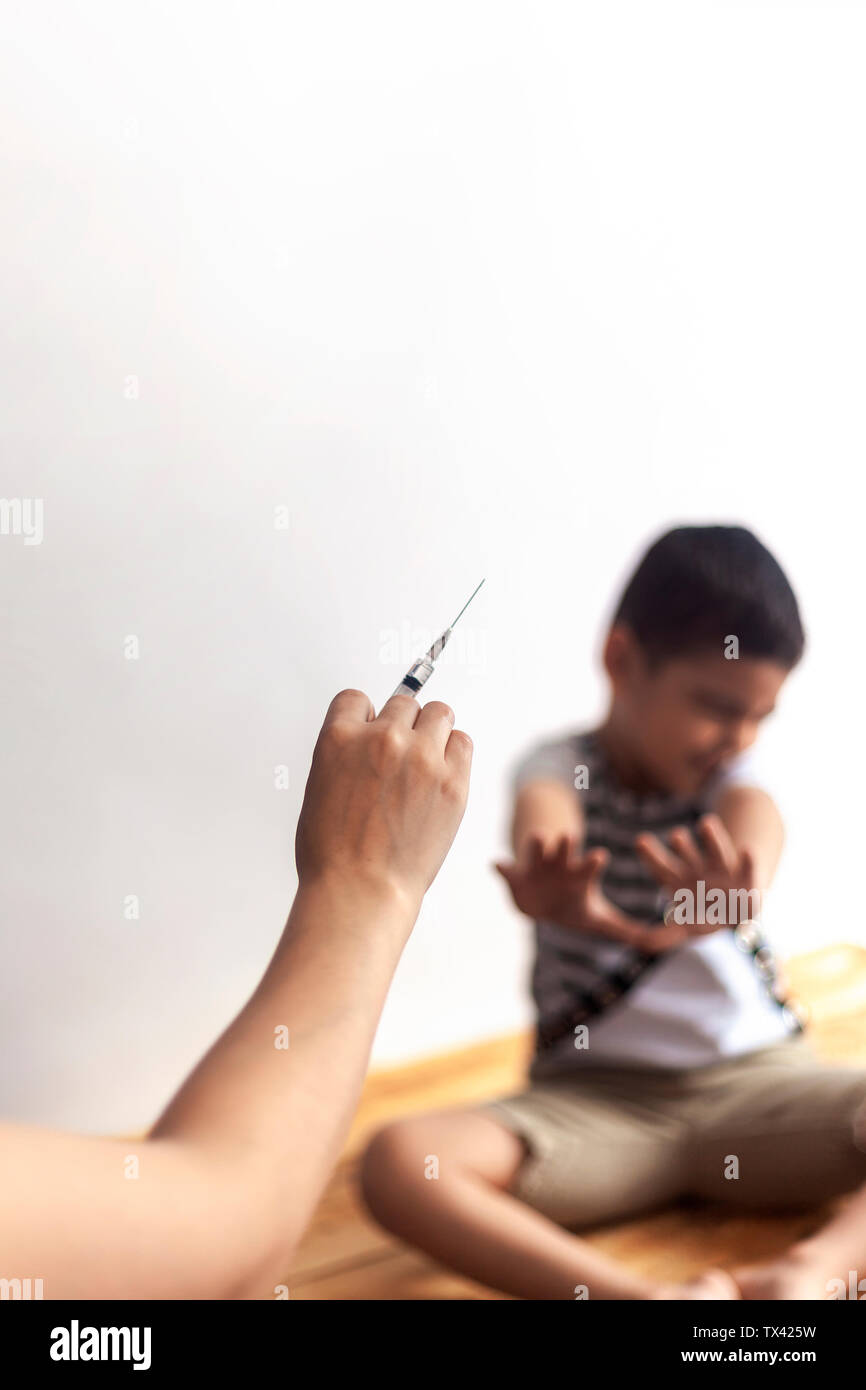 A doctor vaccinating young patient. Little boy scared of injection ...