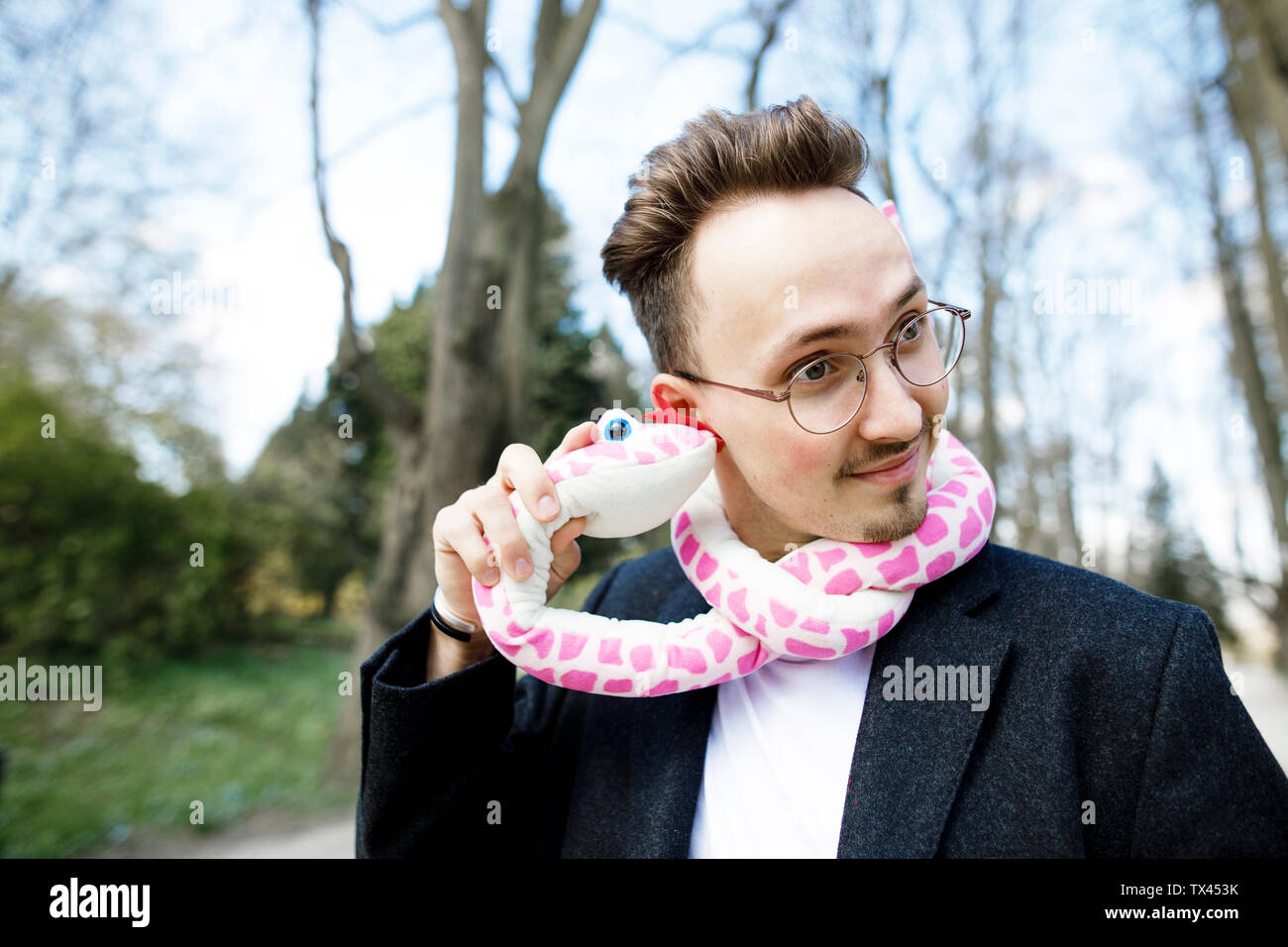 Young man wearing toy snake around his neck Stock Photo - Alamy