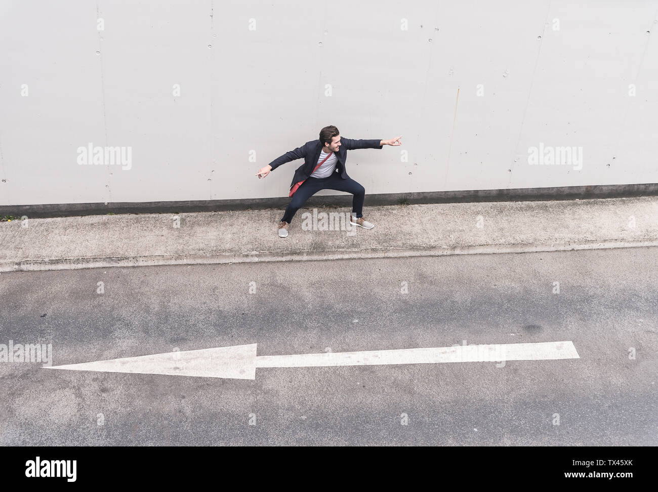 Businessman standing at road with arrow sign pointing his finger Stock ...