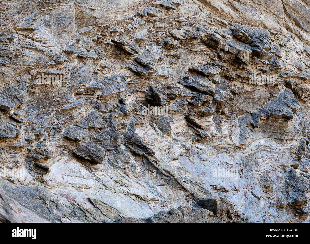 Surface of rocky wall with different hardnesses where the parts of the ...