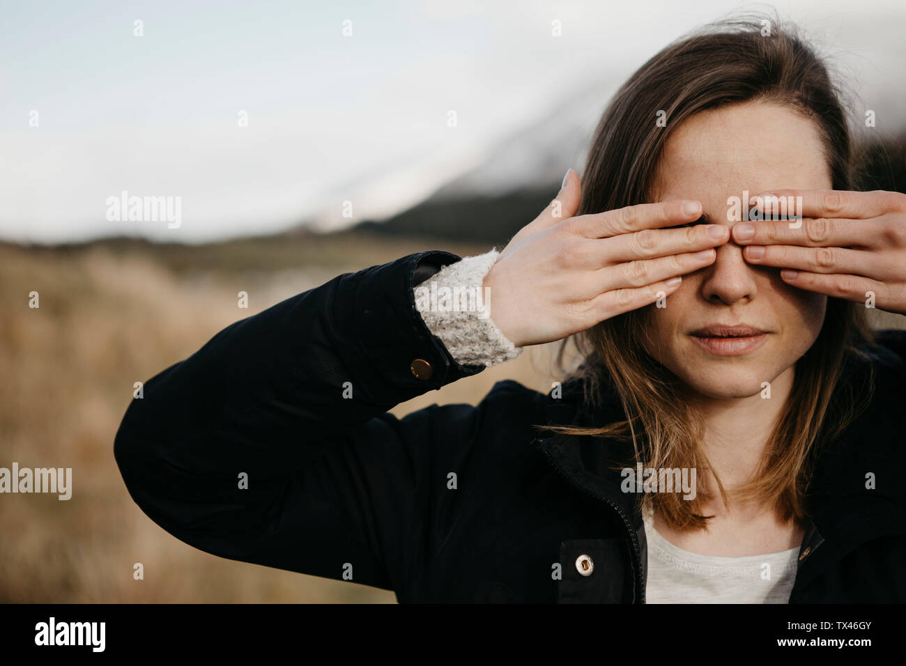 UK, Scotland, young woman covering her eyes in rural landscape Stock ...