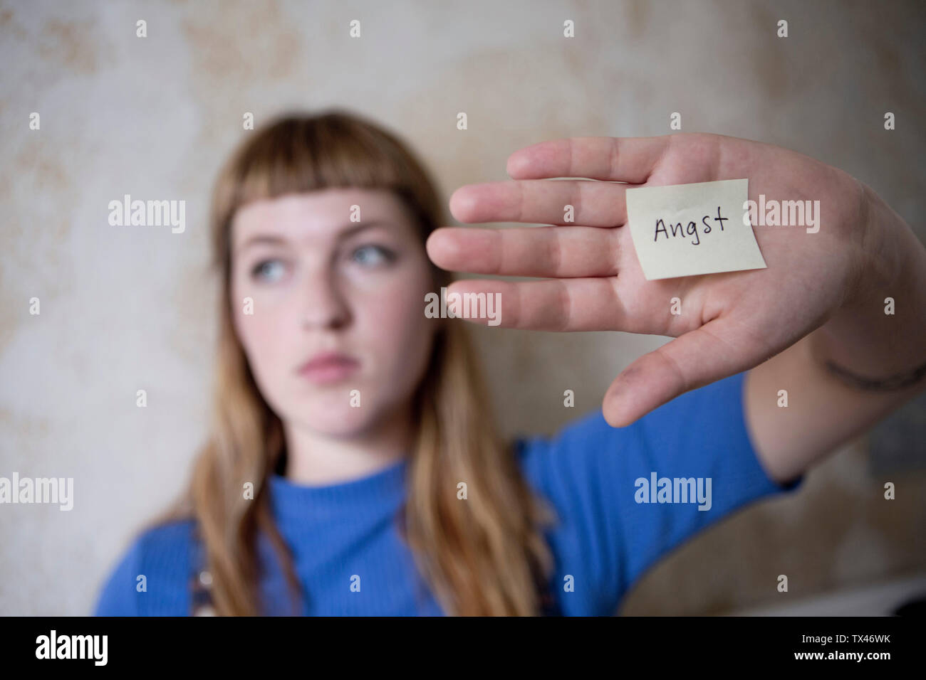 Student holding a hand in front of her eyes, a note with the word fear ...