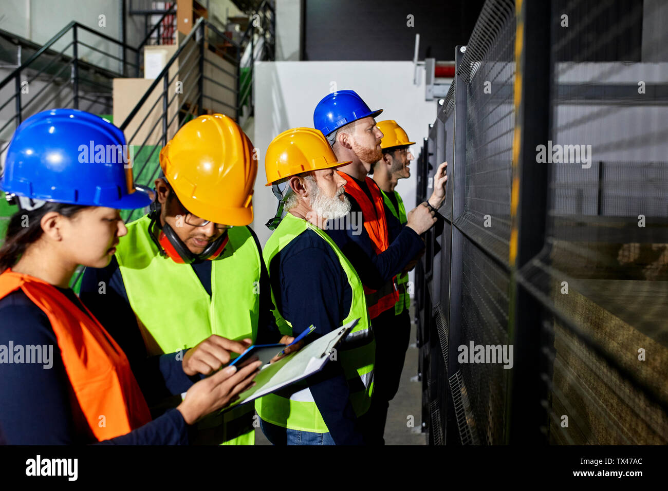 Workers standing in factory workshop Stock Photo - Alamy