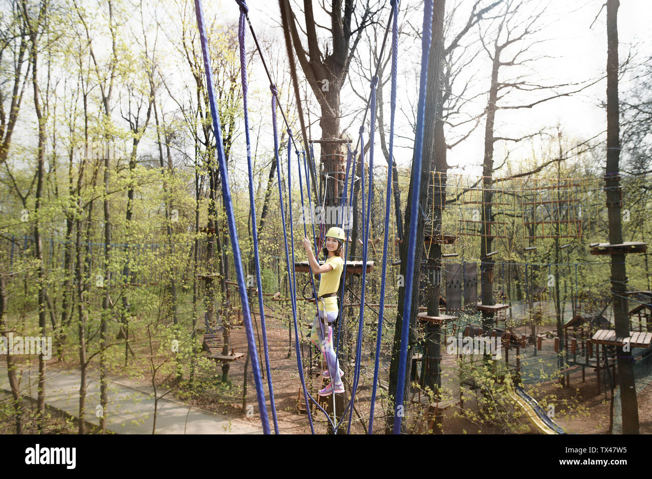 Young woman wearing yellow t-shirt and helmet in a rope course Stock ...