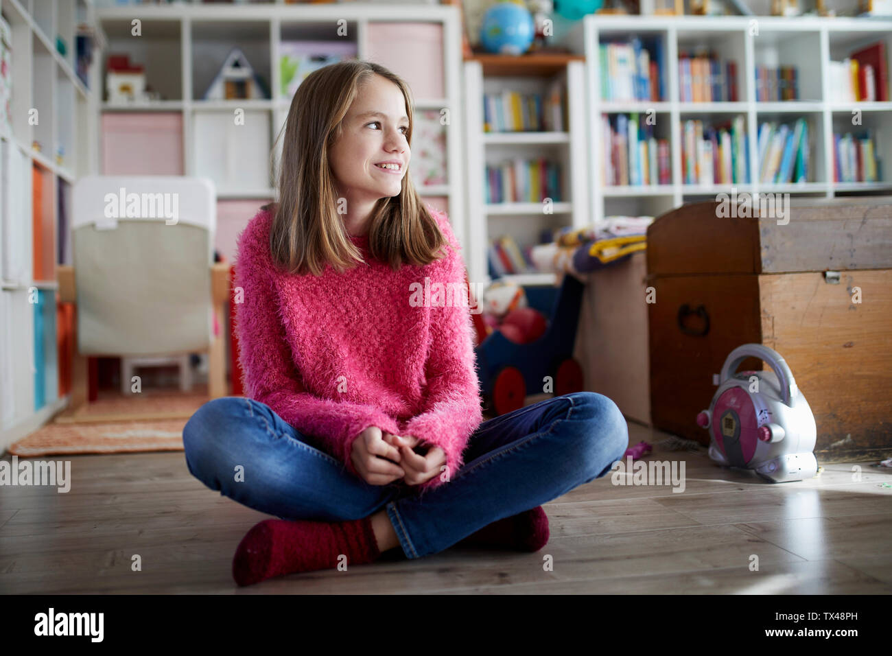 Confident girl sitting cross-legged on floor of her room Stock Photo ...
