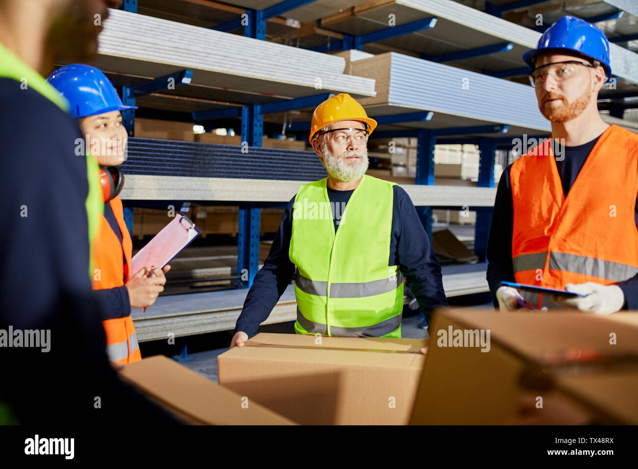 Workers talking in factory warehouse Stock Photo - Alamy