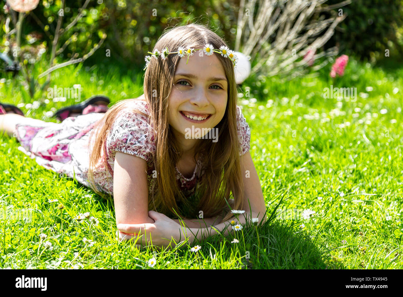 Portrait of happy girl lying on meadow in garden Stock Photo - Alamy