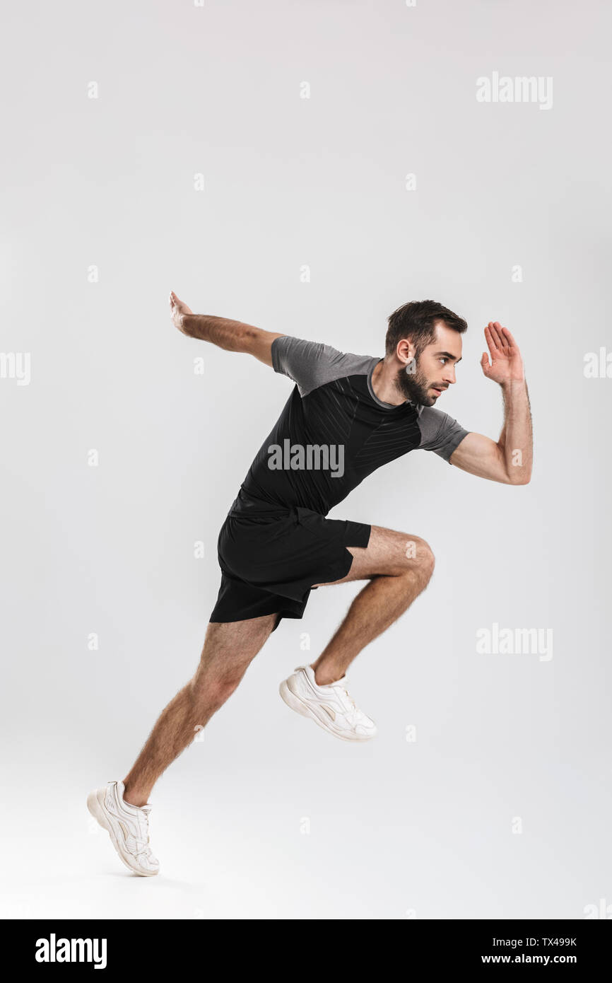 Full length side view portrait of a confident young sportsman jumping ...