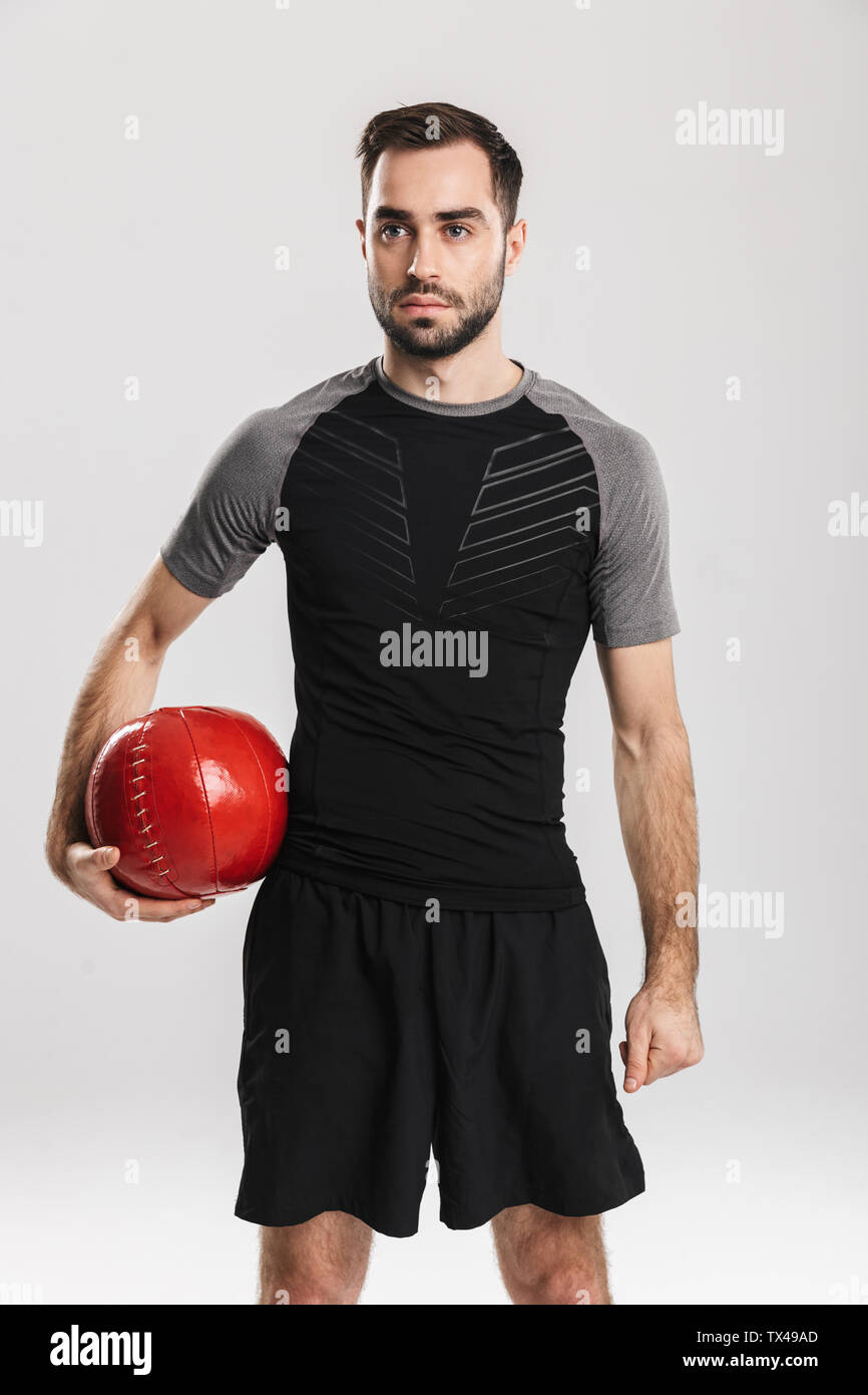 Confident motivated sportsman doing exercises with heavy ball isolated ...
