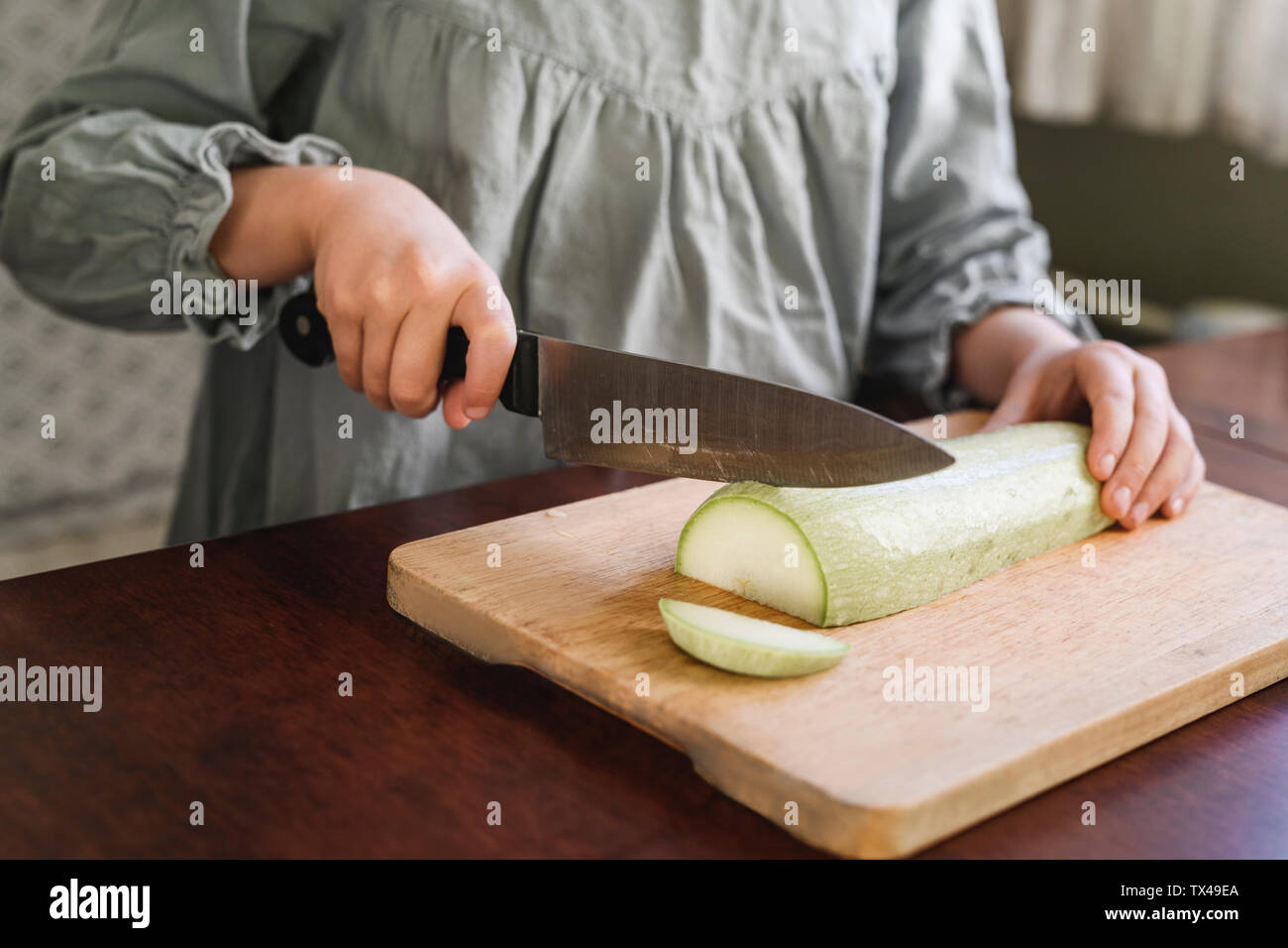 Girl's hands slicing courgette, partial view Stock Photo - Alamy