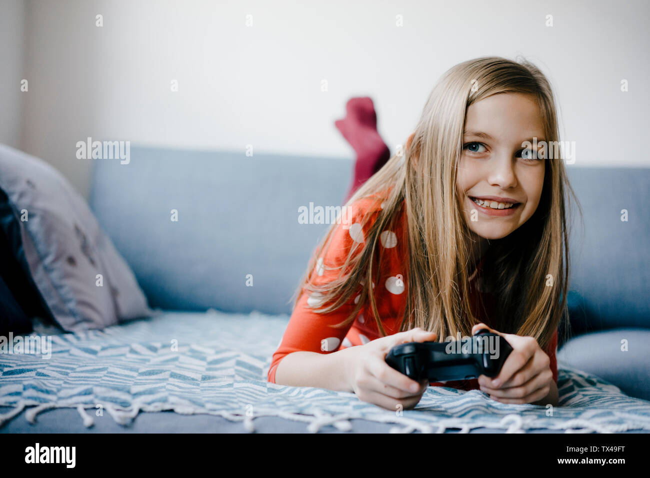 Happy girl playing video game at home Stock Photo - Alamy