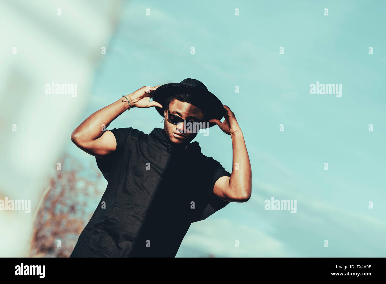 Portrait of a young man with a hat, hands on hat Stock Photo - Alamy
