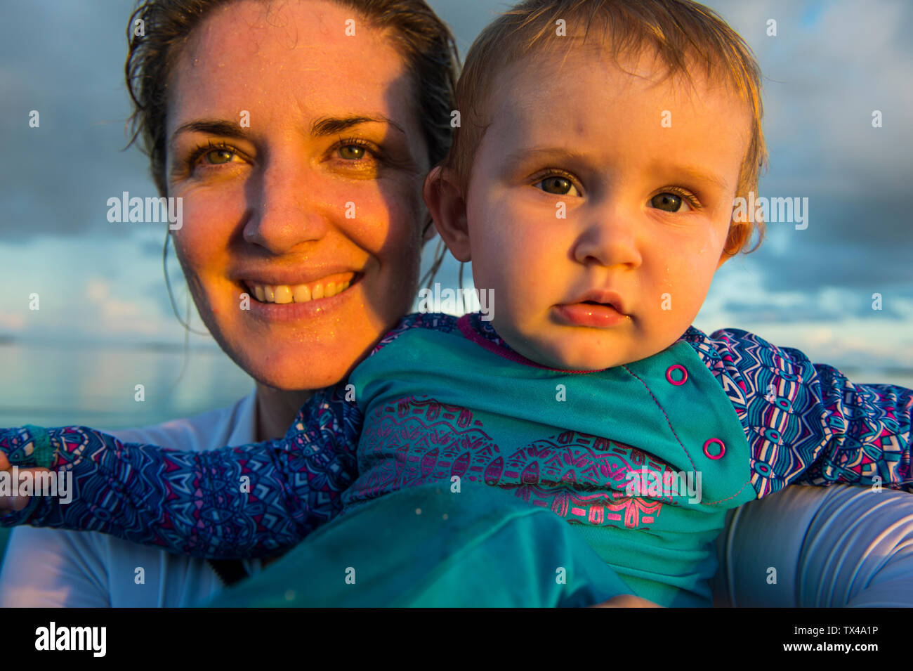 Mother holding her happy baby in sunlight Stock Photo - Alamy