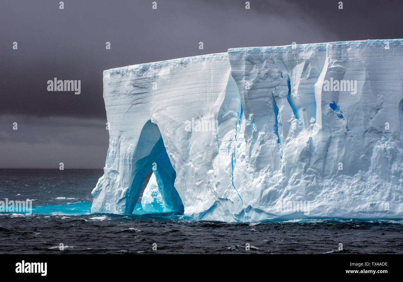 Massive iceberg floating in the sea in Antarctica showing an arch ...