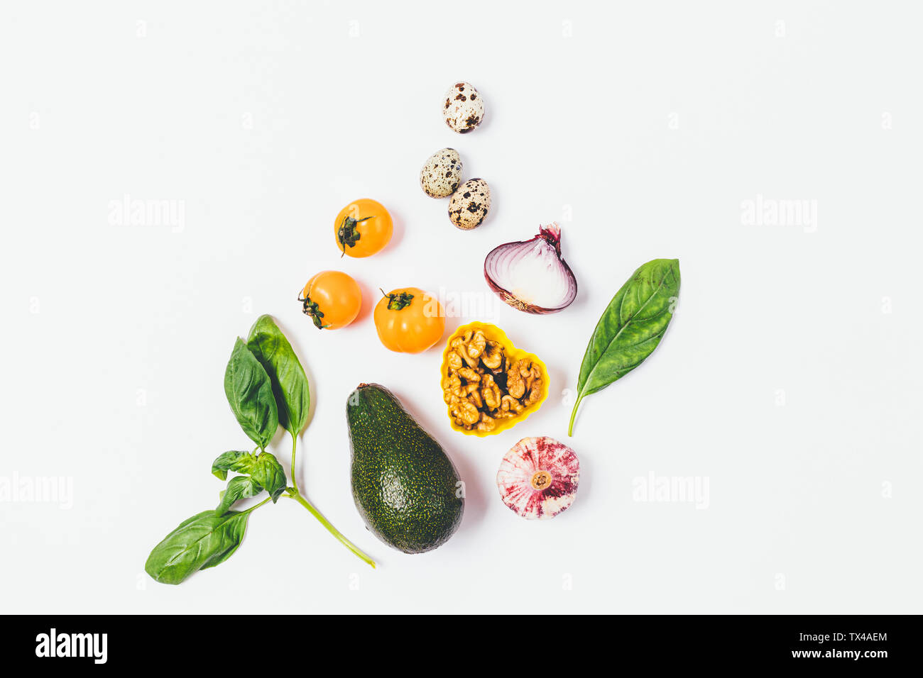 Creative food background of fresh greens, avocado, tomatoes, nuts and ...