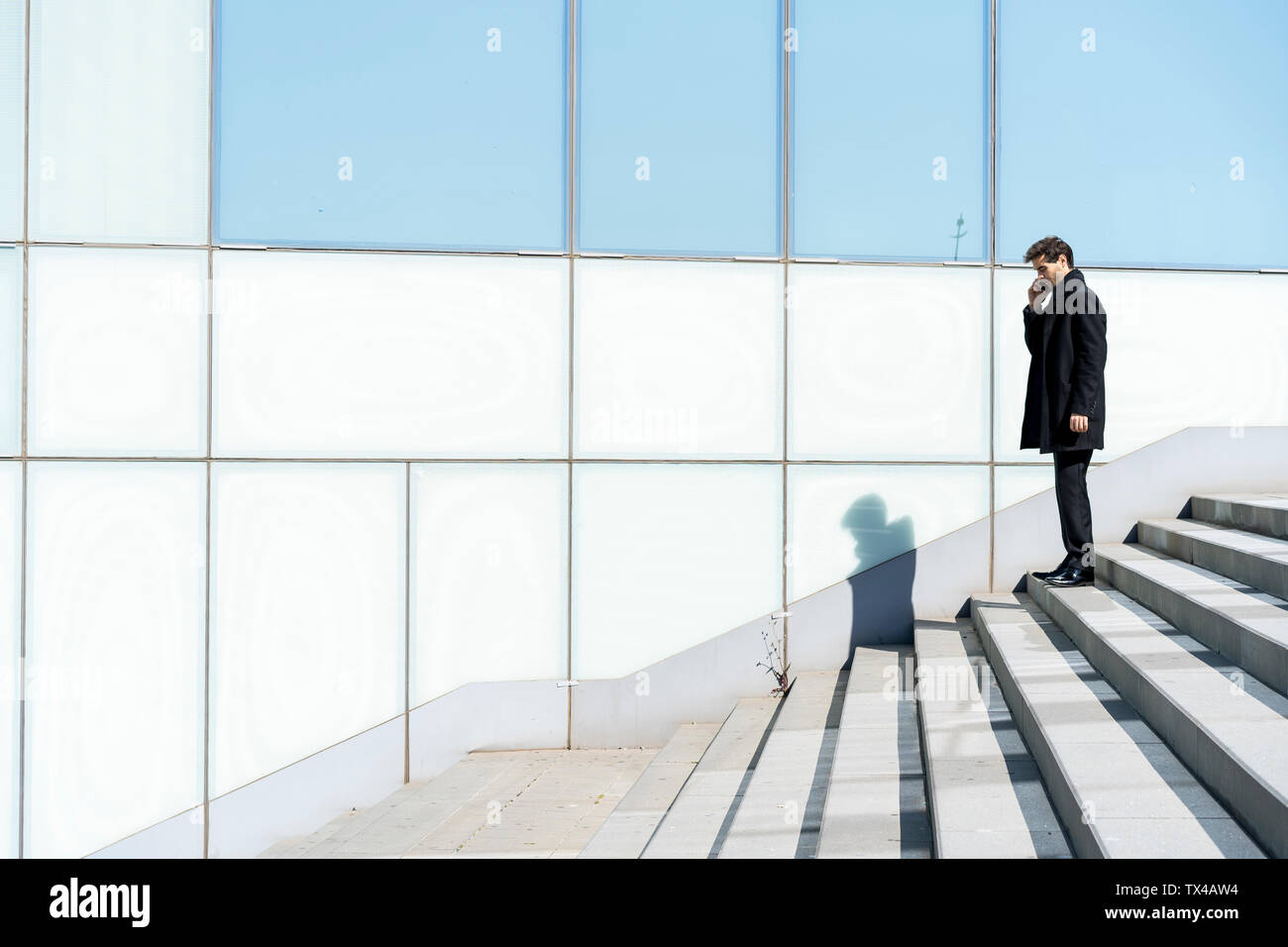 Businessman on cell phone on stairs in the city Stock Photo - Alamy