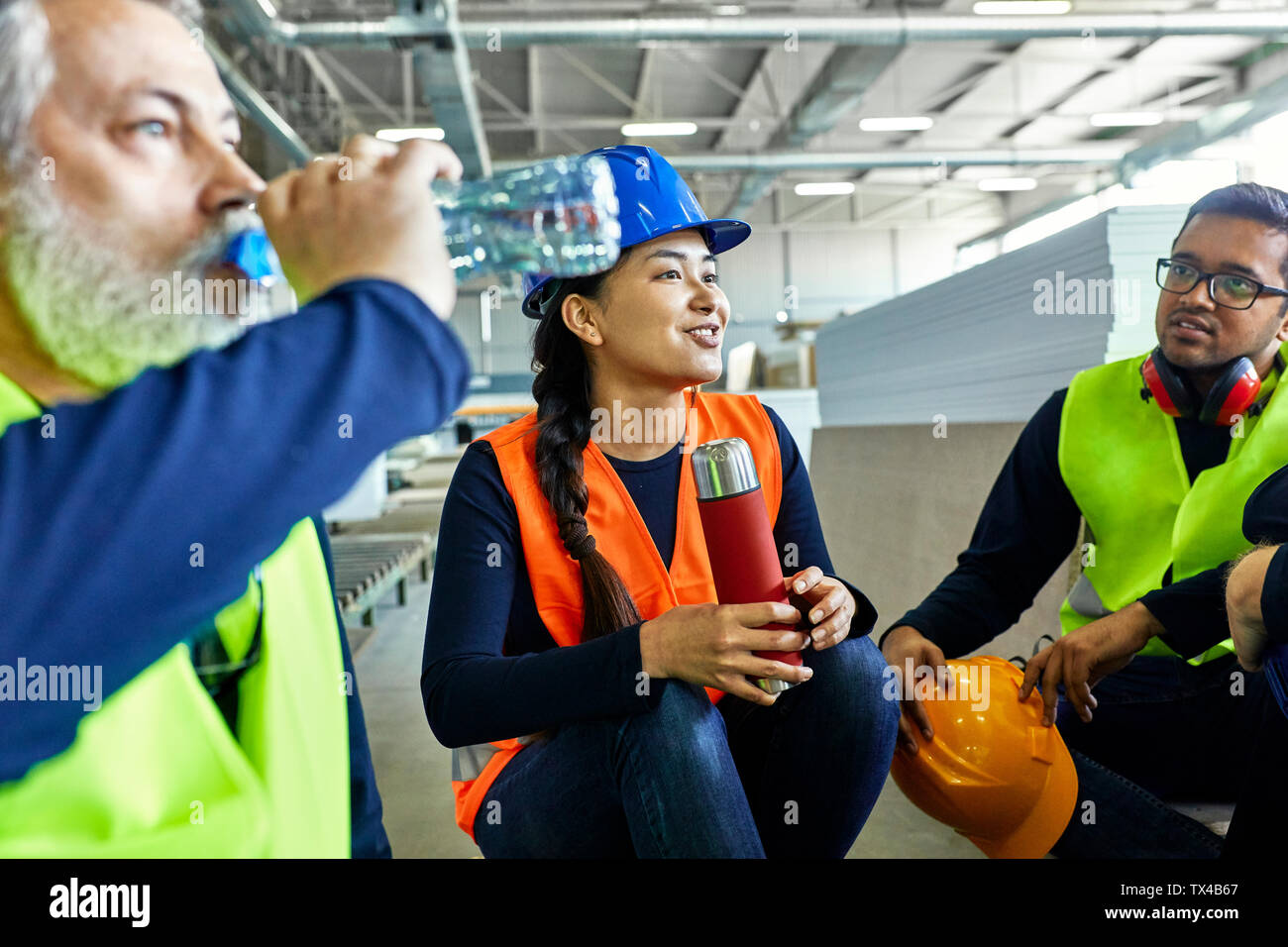 Workers in factory having lunch break together Stock Photo - Alamy