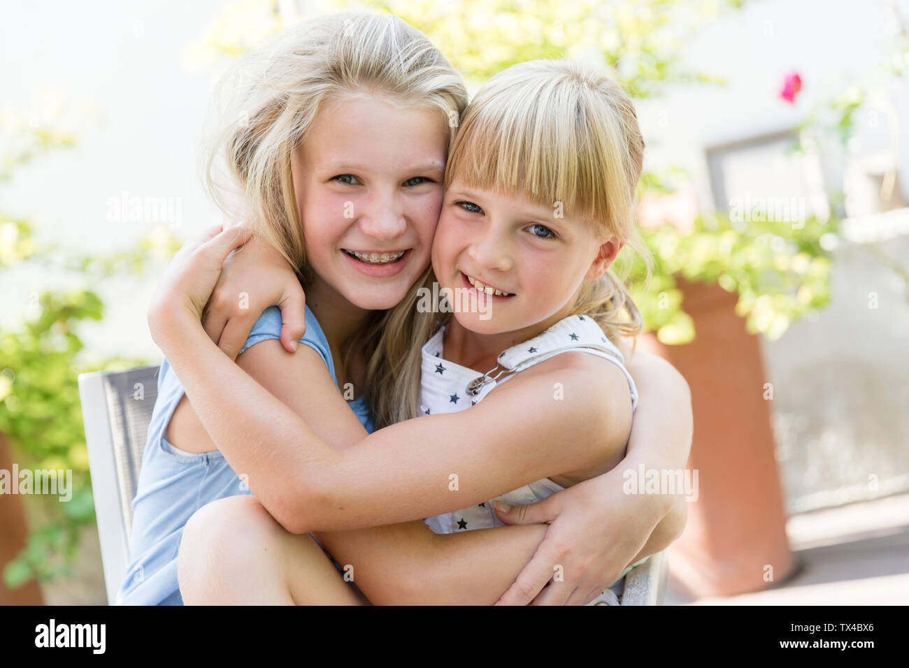 Portrait of two girls hugging outdoors Stock Photo - Alamy