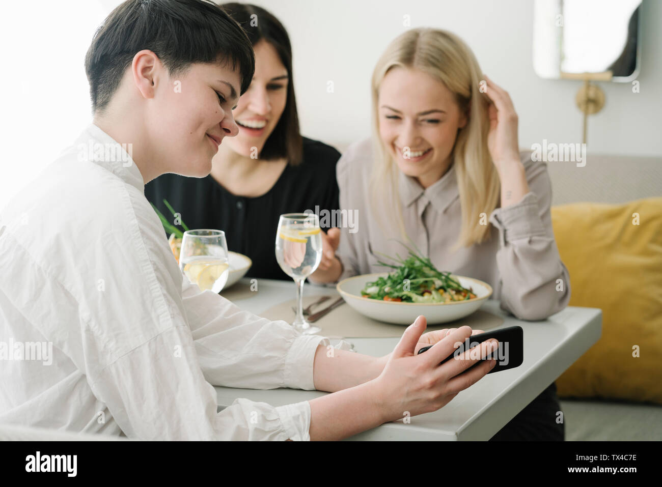 Happy friends using smartphone hi-res stock photography and images - Alamy