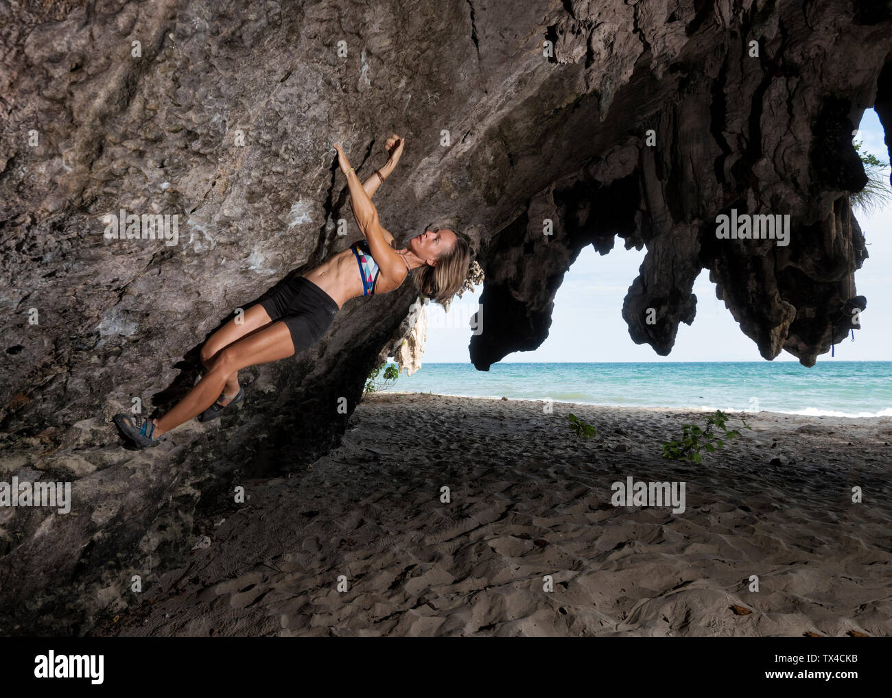 Thailand, Krabi, Lao liang island, woman bouldering in rock wall at the ...