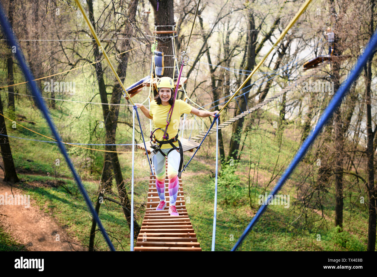 Young woman wearing yellow t-shirt and helmet in a rope course Stock ...