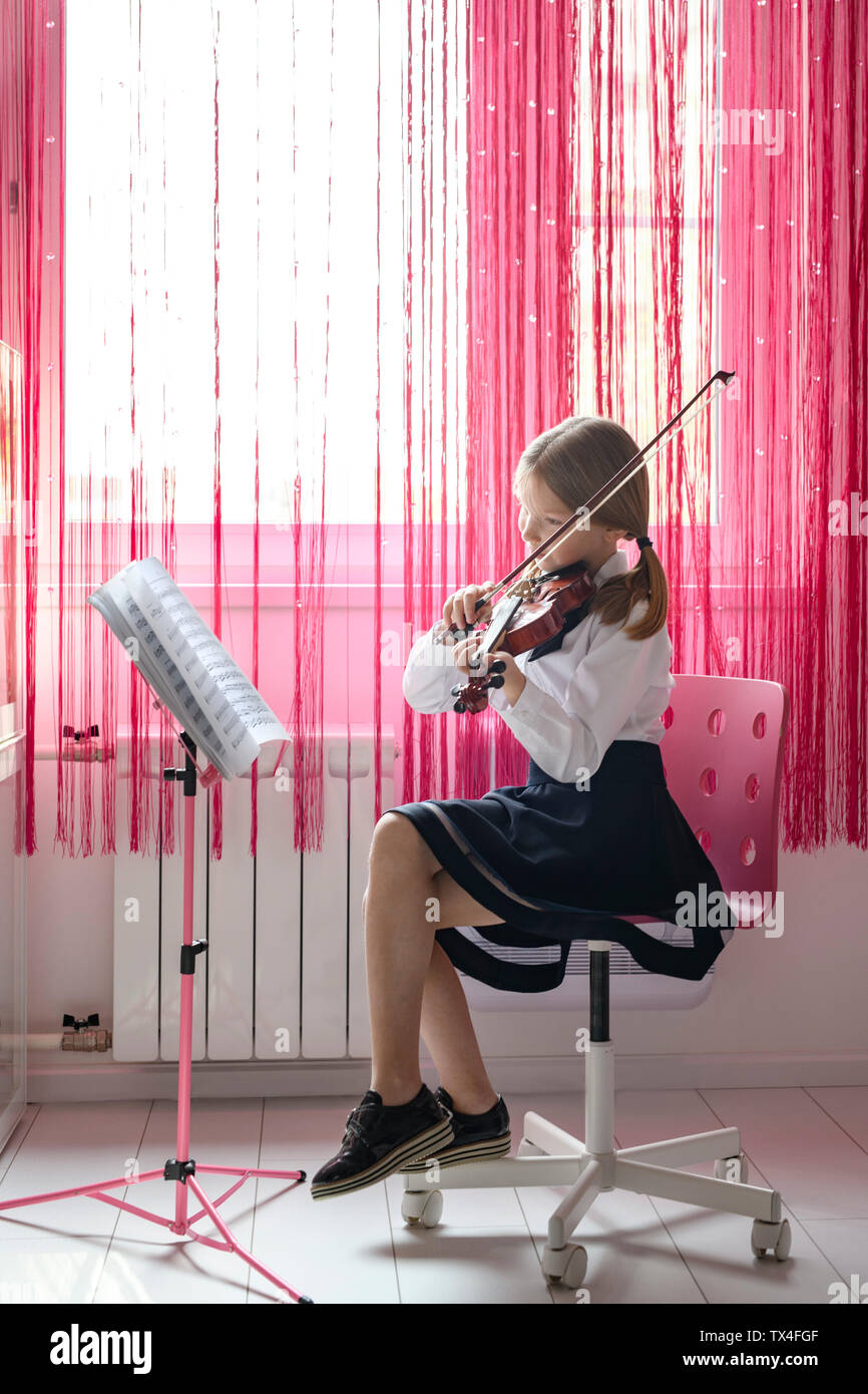Girl sitting at the window at home playing violin Stock Photo - Alamy