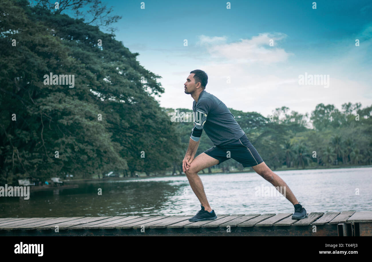 sport man exercise and worm up on bridge with river background, runner ...