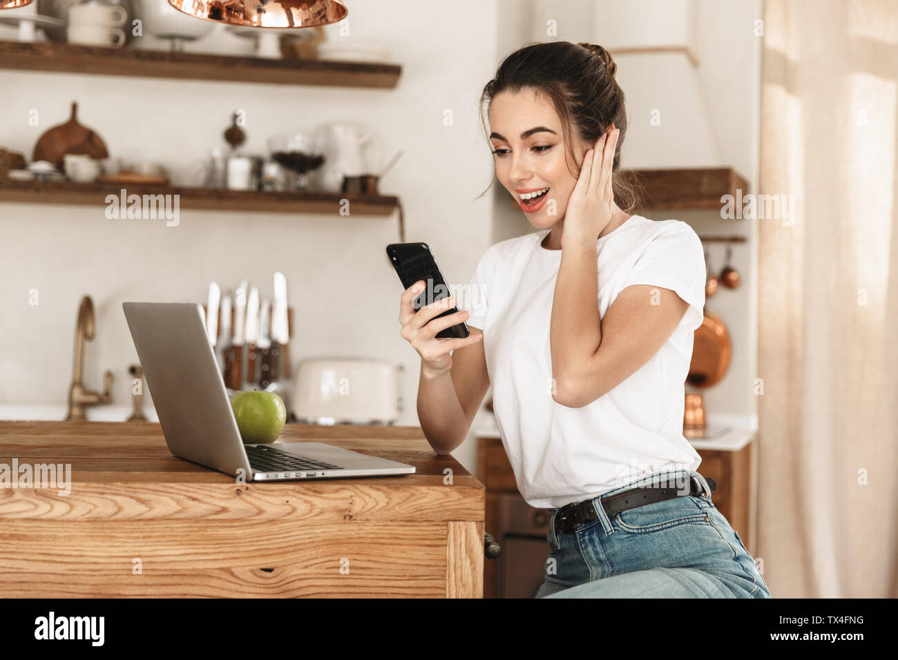 Image of a beautiful young student girl sitting indoors using laptop ...