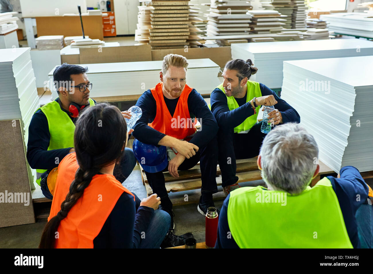 Workers in factory having lunch break together Stock Photo - Alamy