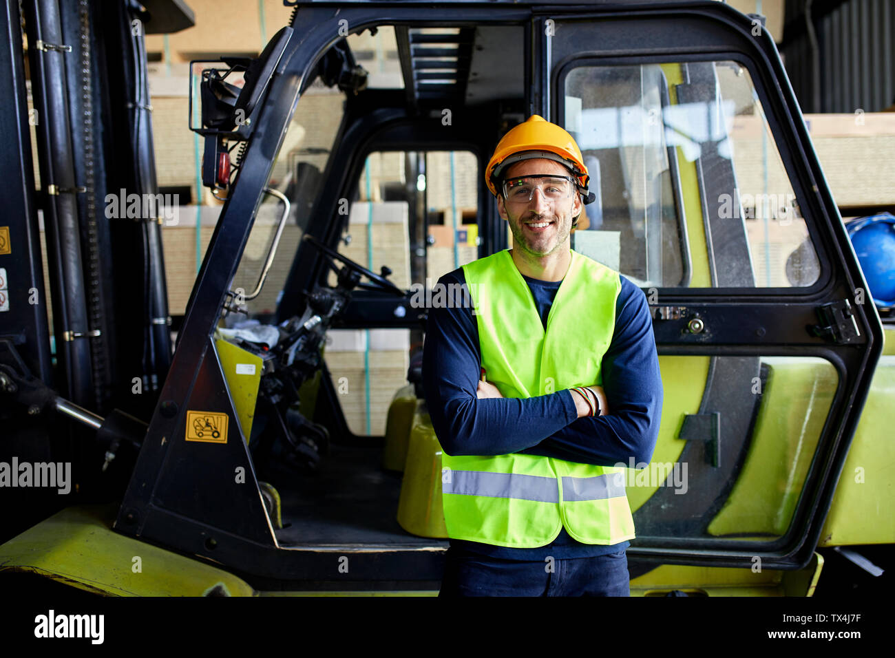 Portrait of confident worker at forklift in factory Stock Photo - Alamy