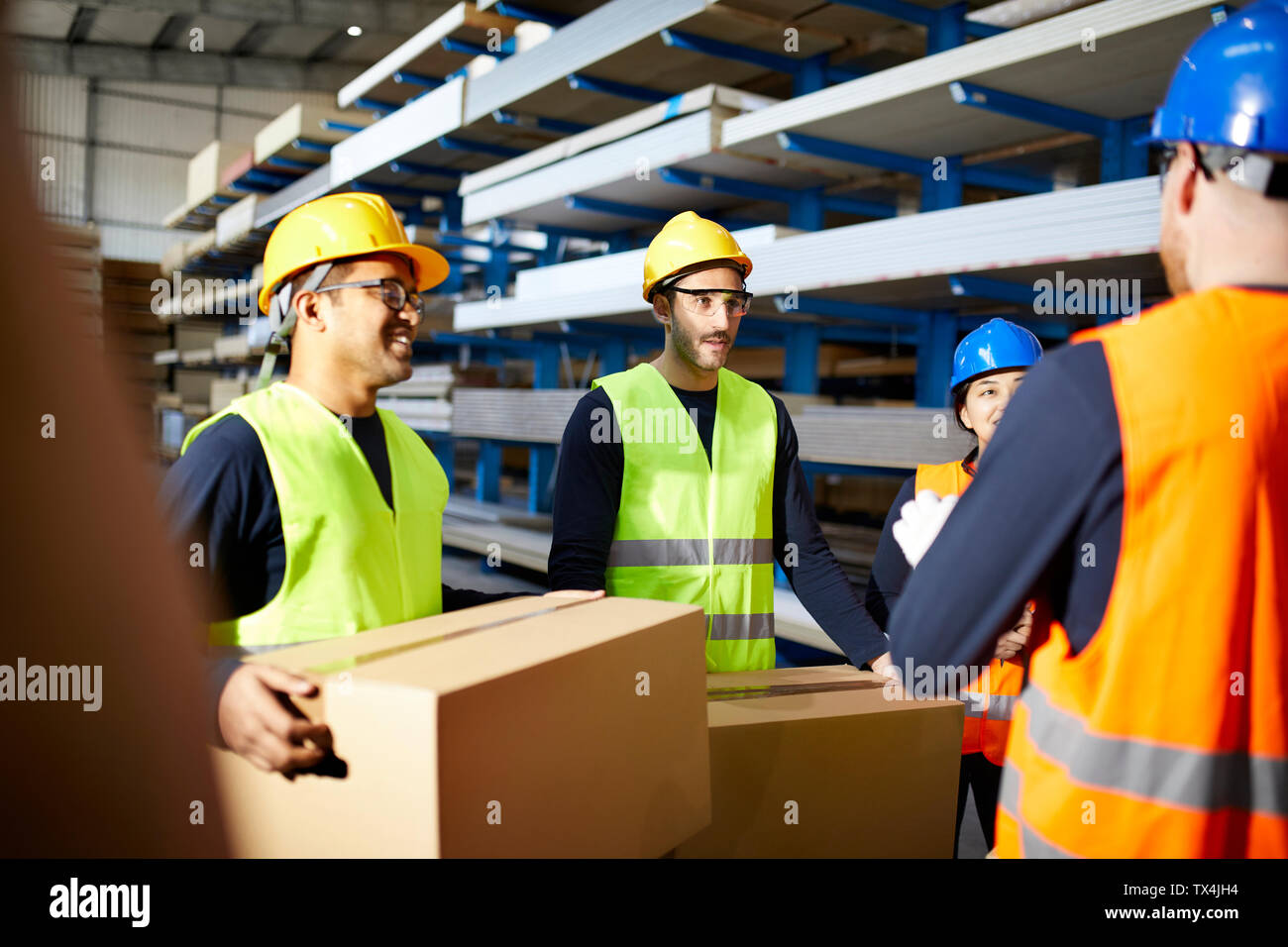 Workers talking in factory warehouse Stock Photo - Alamy
