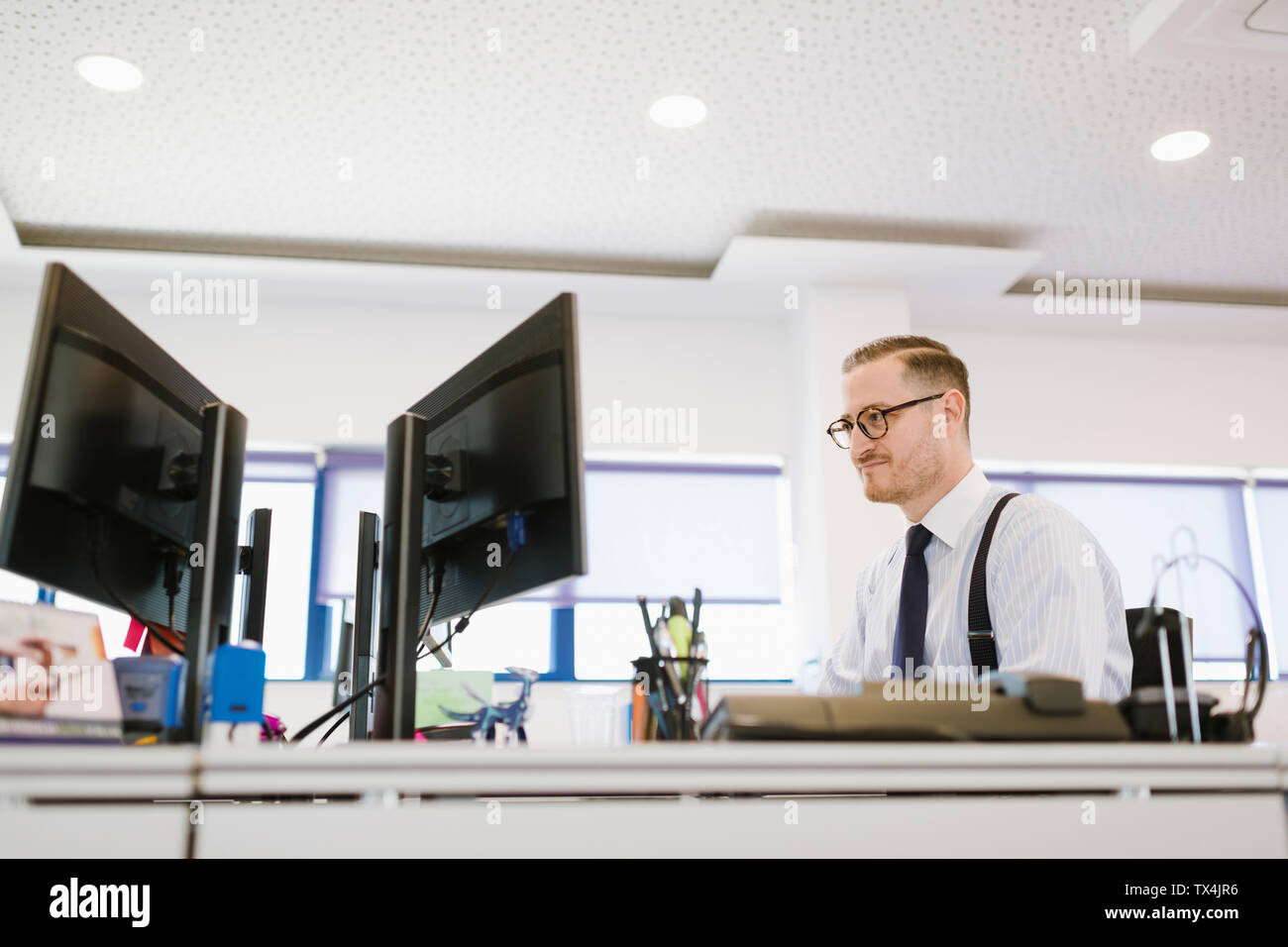 Businessman using computer at desk in office Stock Photo - Alamy