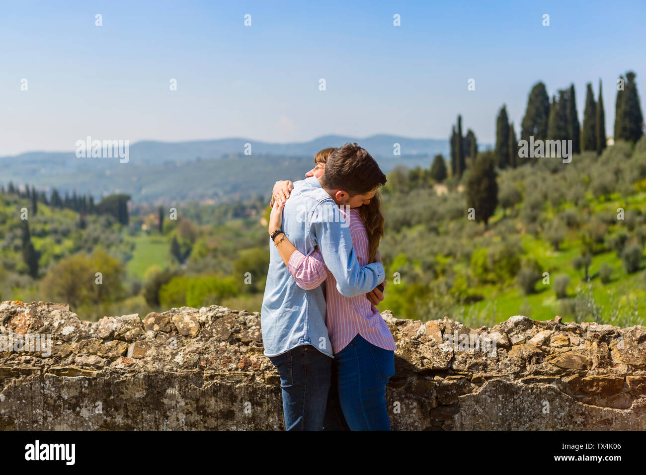 Young couple embracing at wall in Florence, Tuscany, Italy Stock Photo ...