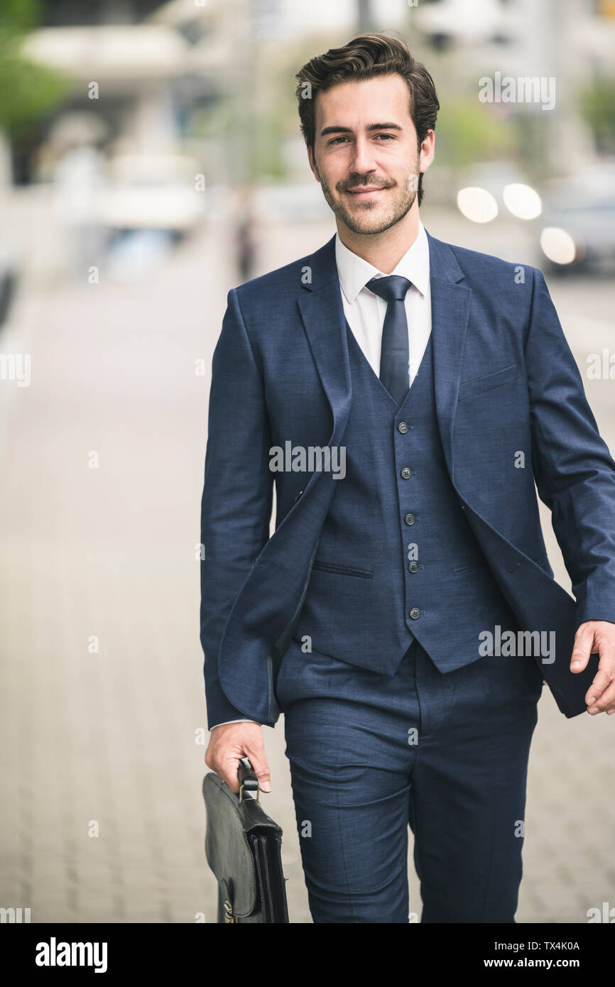 Confident businessman walking on pavement hi-res stock photography and ...
