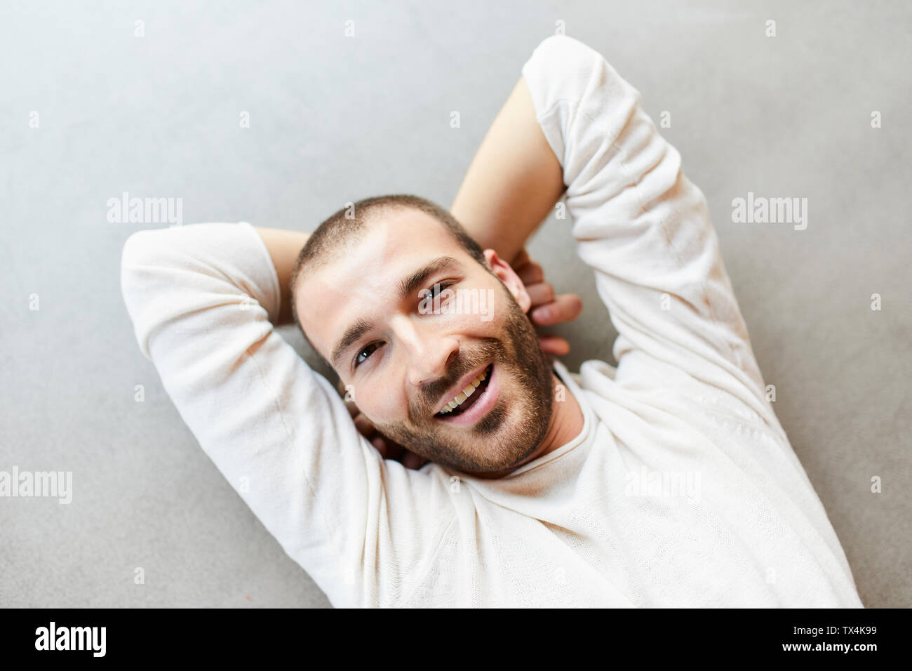 Portrait of happy young man lying on the floor Stock Photo - Alamy