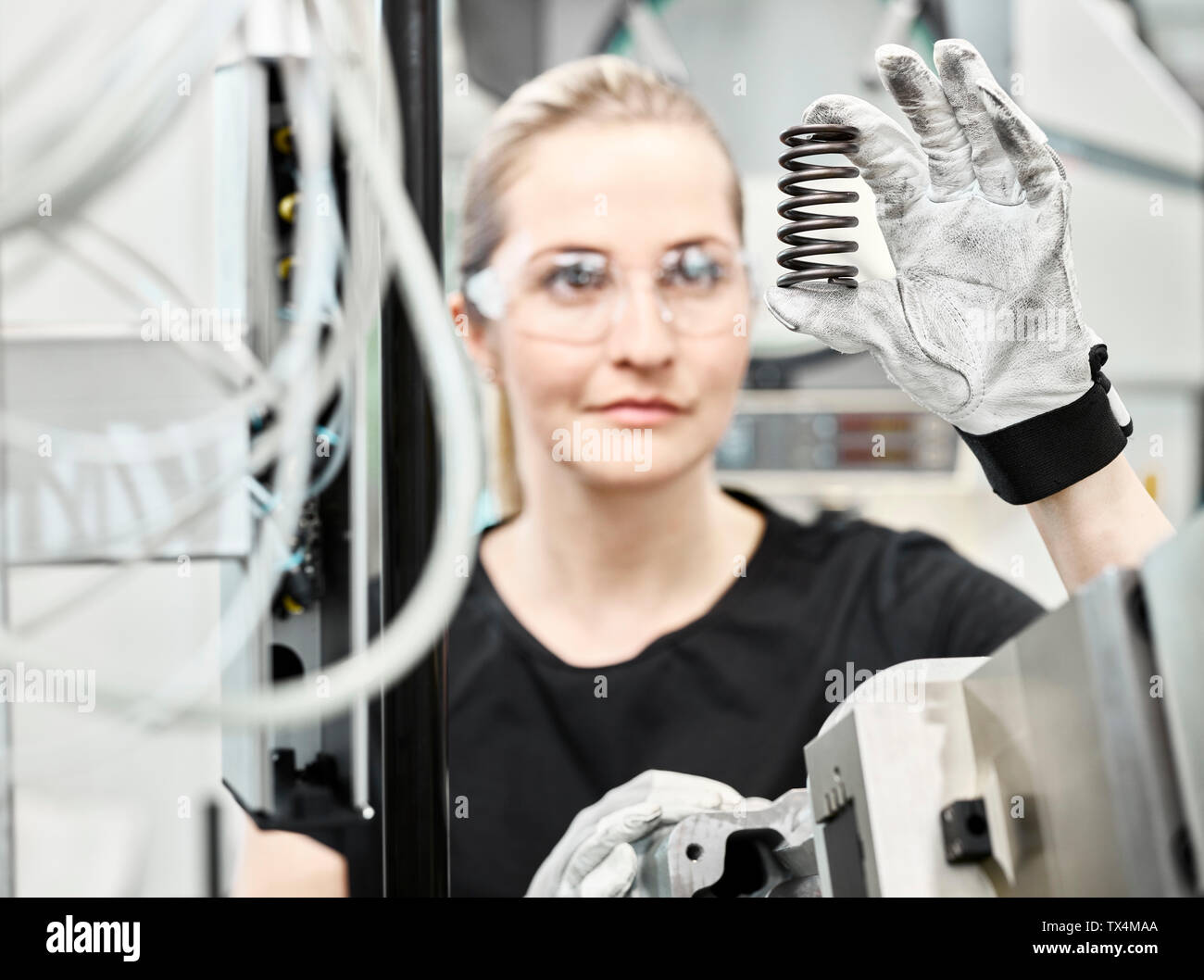 Woman working on a machine, looking on spring Stock Photo - Alamy