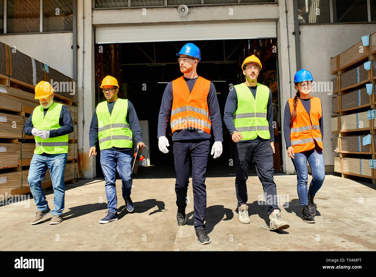 Group of workers walking on factory yard Stock Photo - Alamy