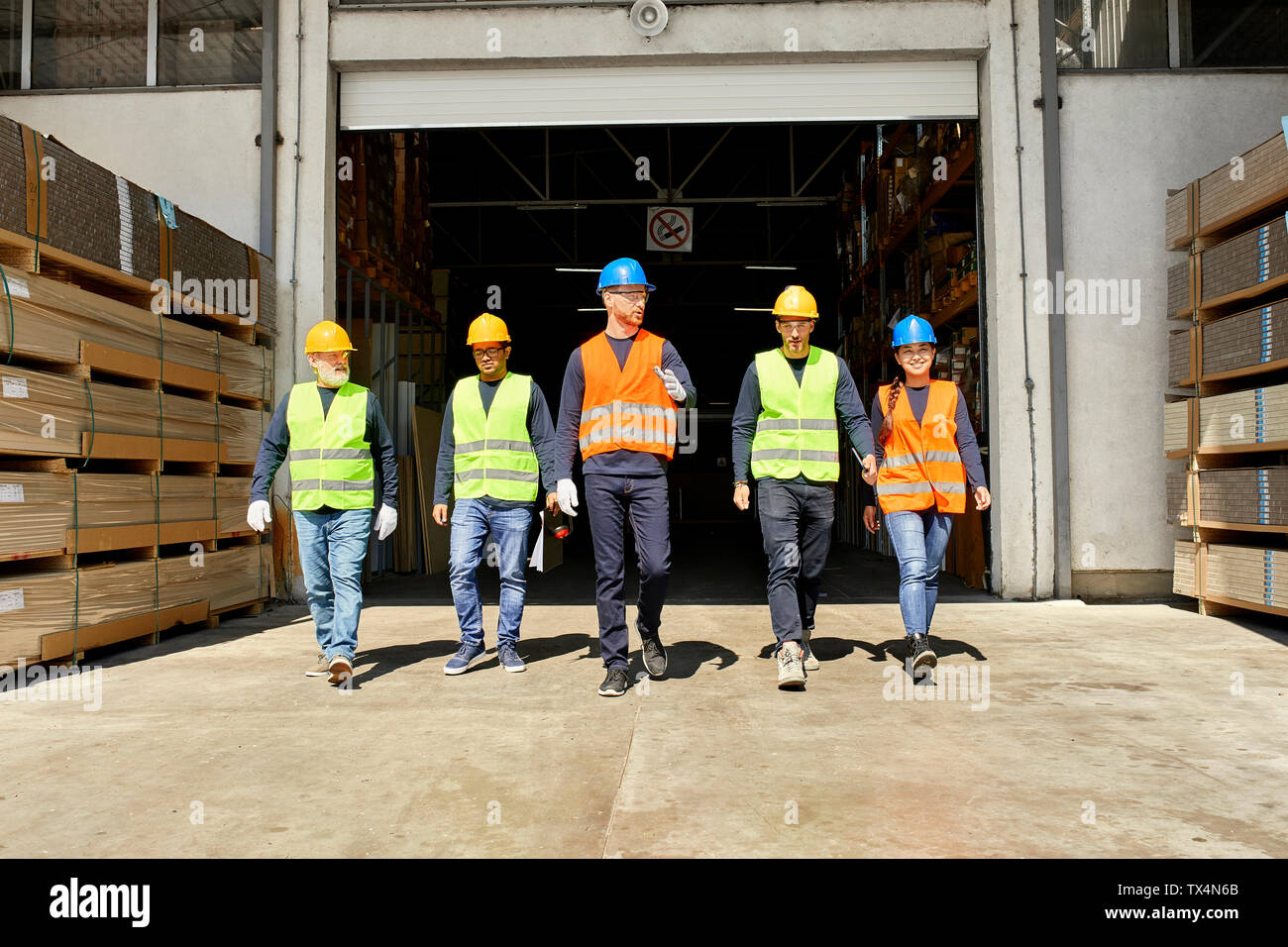 Group of workers walking on factory yard Stock Photo - Alamy