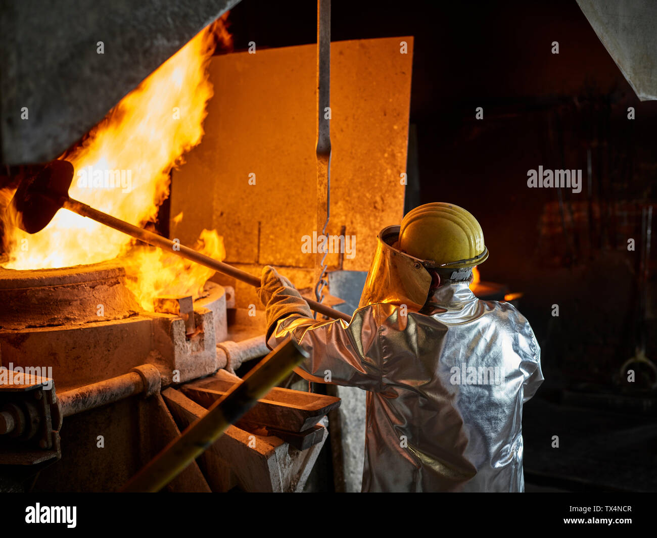Industry, worker at furnace during melting copper, wearing a fire ...
