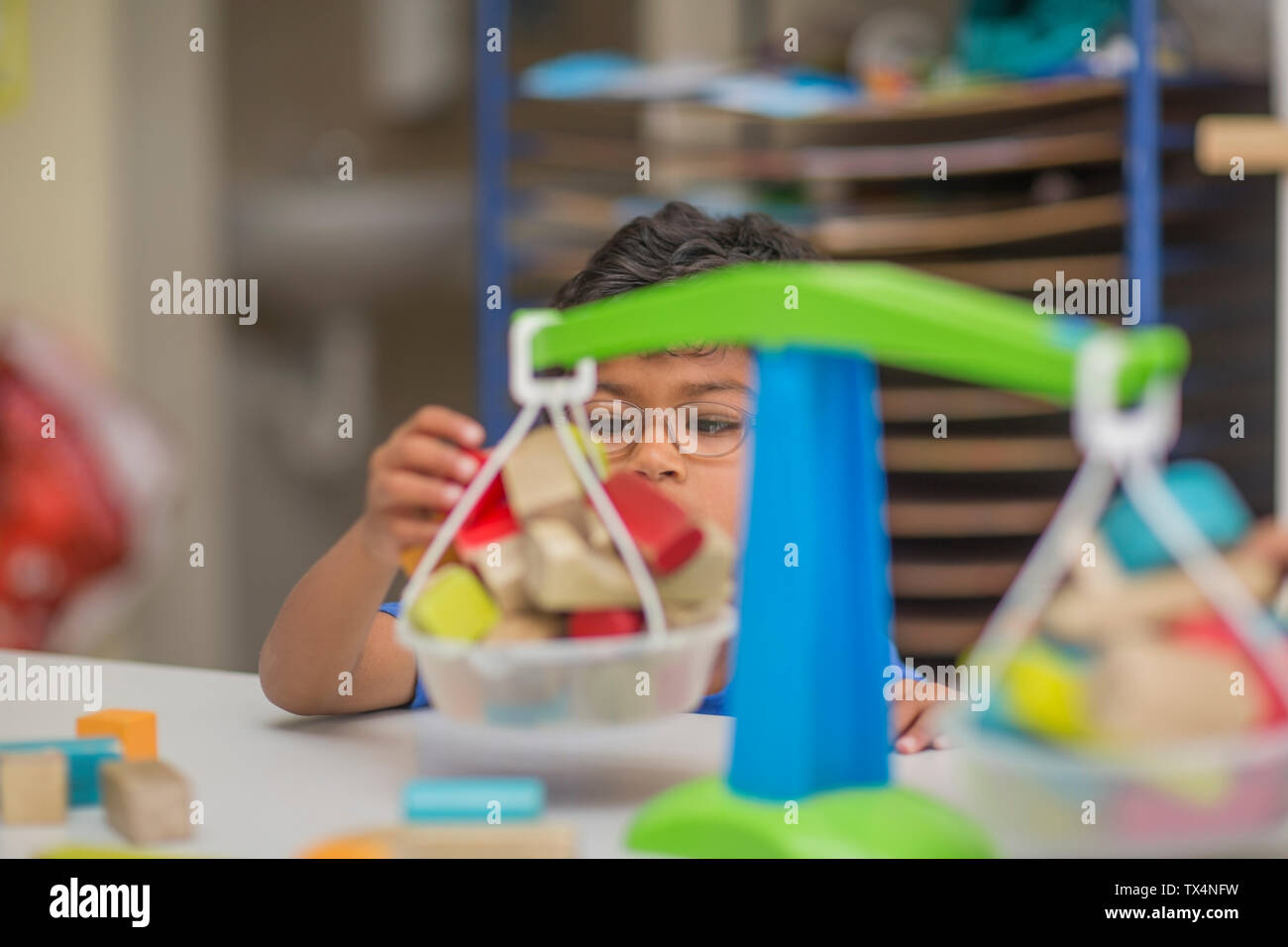 Boy playing with toy scales in kindergarten Stock Photo - Alamy