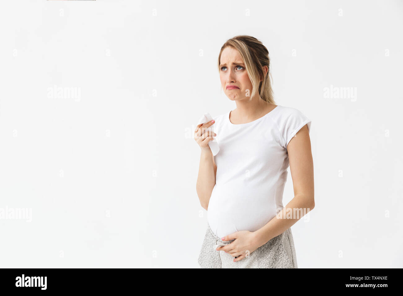 Image of a sad young pregnant woman posing isolated over white wall ...
