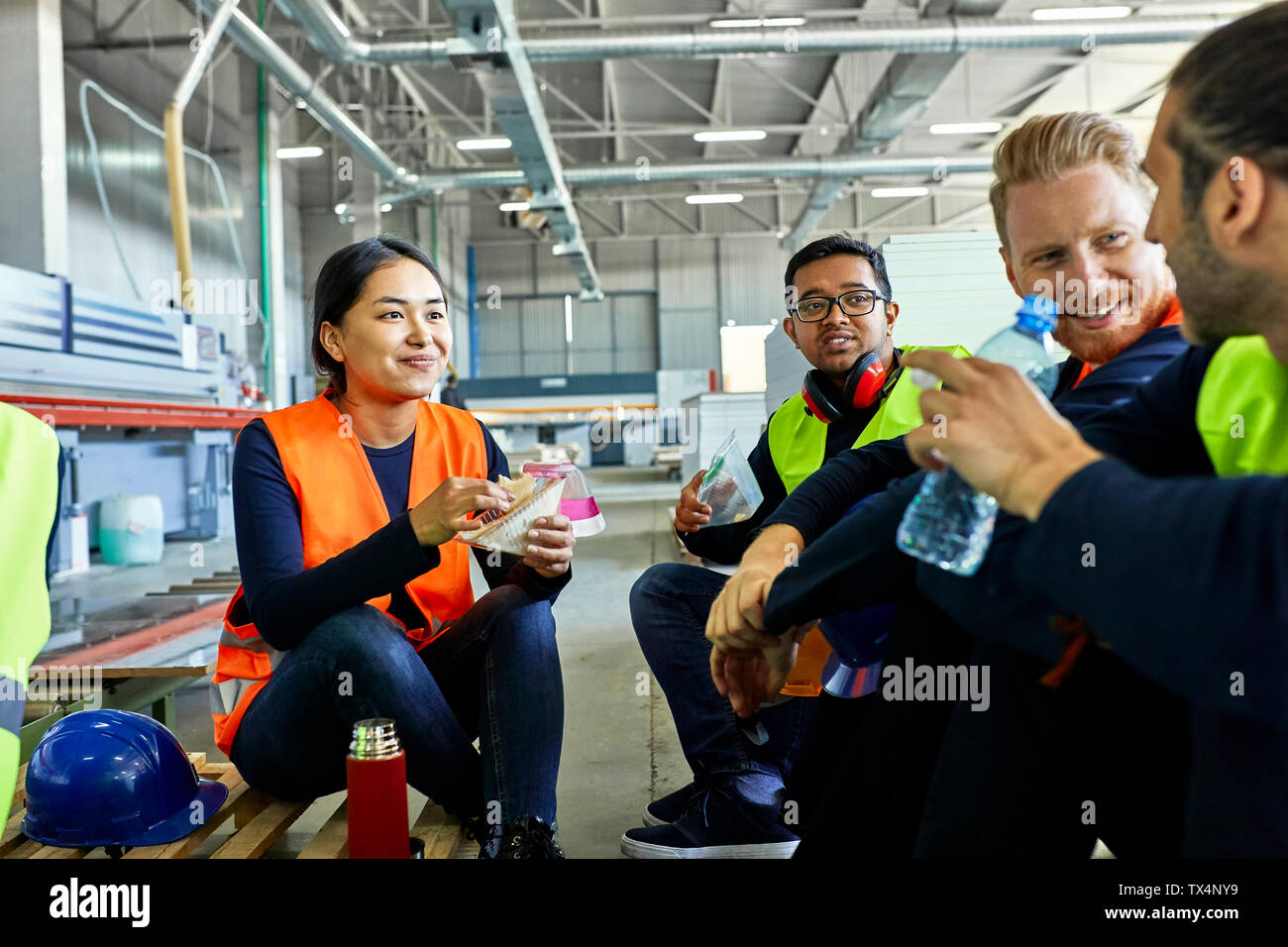 Workers in factory having lunch break together Stock Photo - Alamy