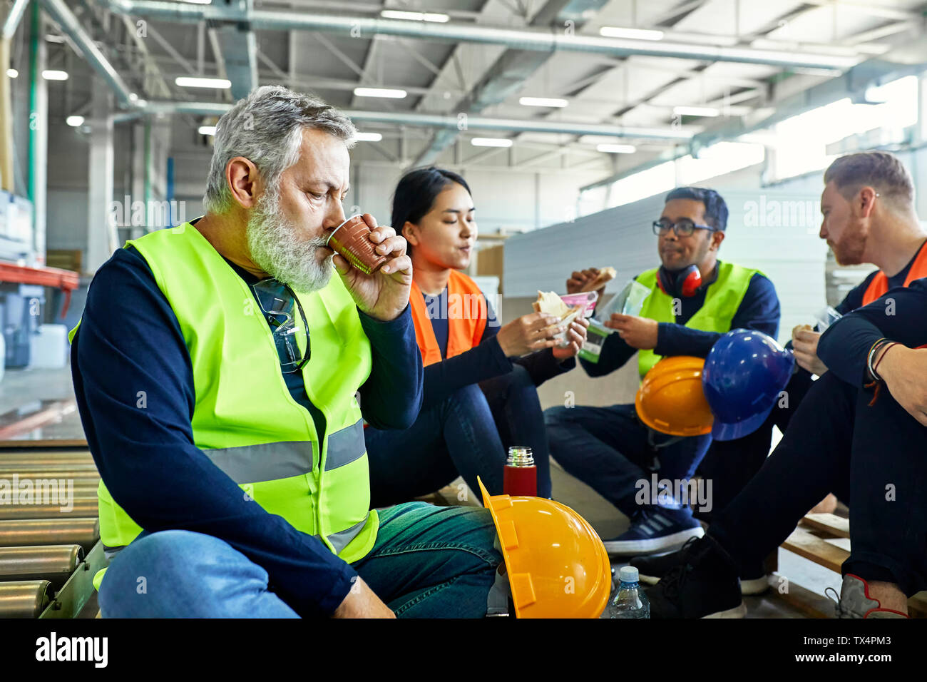 Workers in factory having lunch break together Stock Photo - Alamy